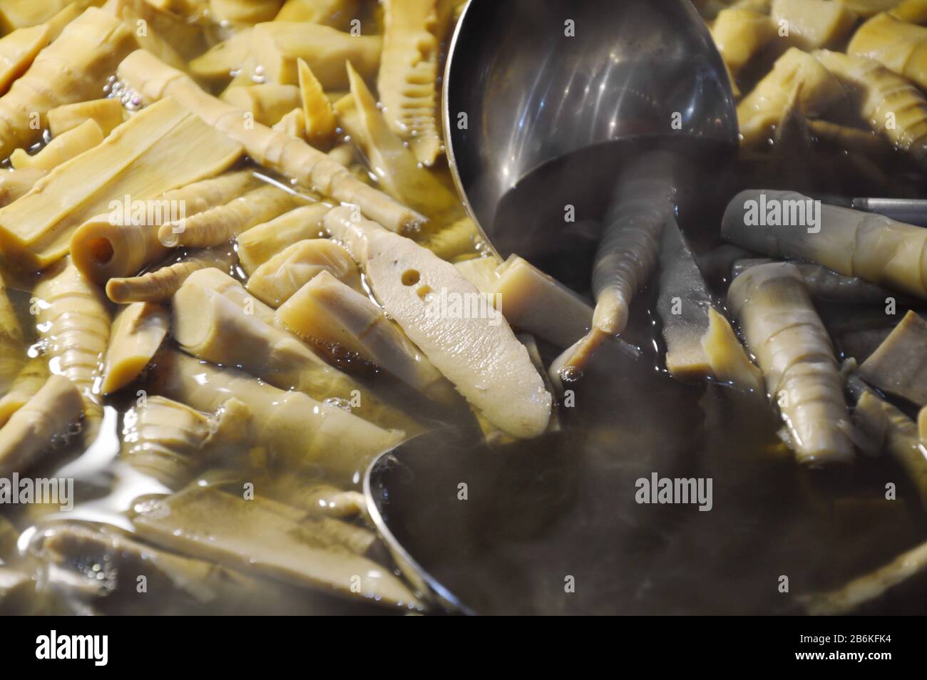 boiled bamboo shoot with salt water in stainless basin on market Stock ...