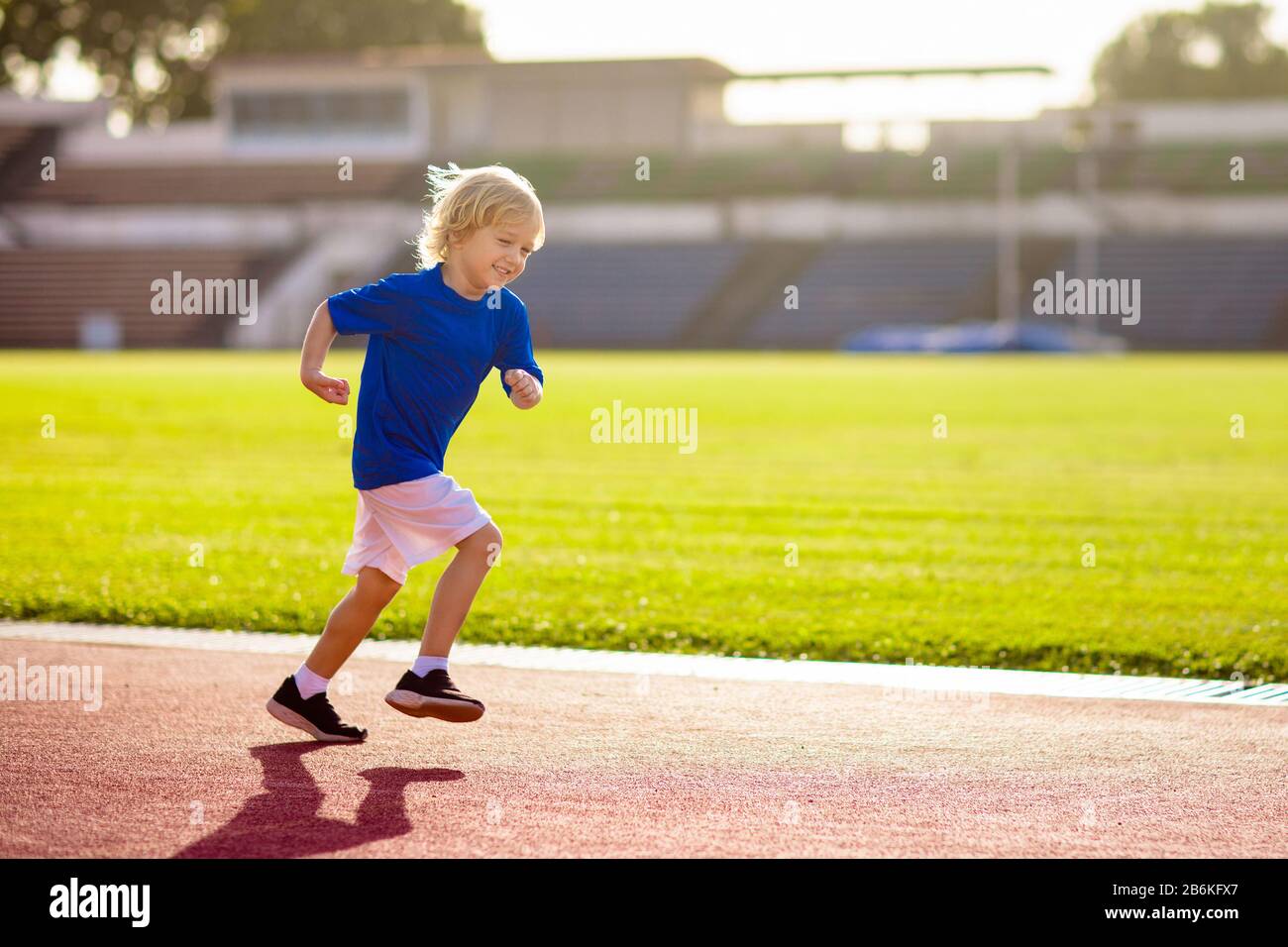 Child running in stadium. Kids run on outdoor track. Healthy sport ...