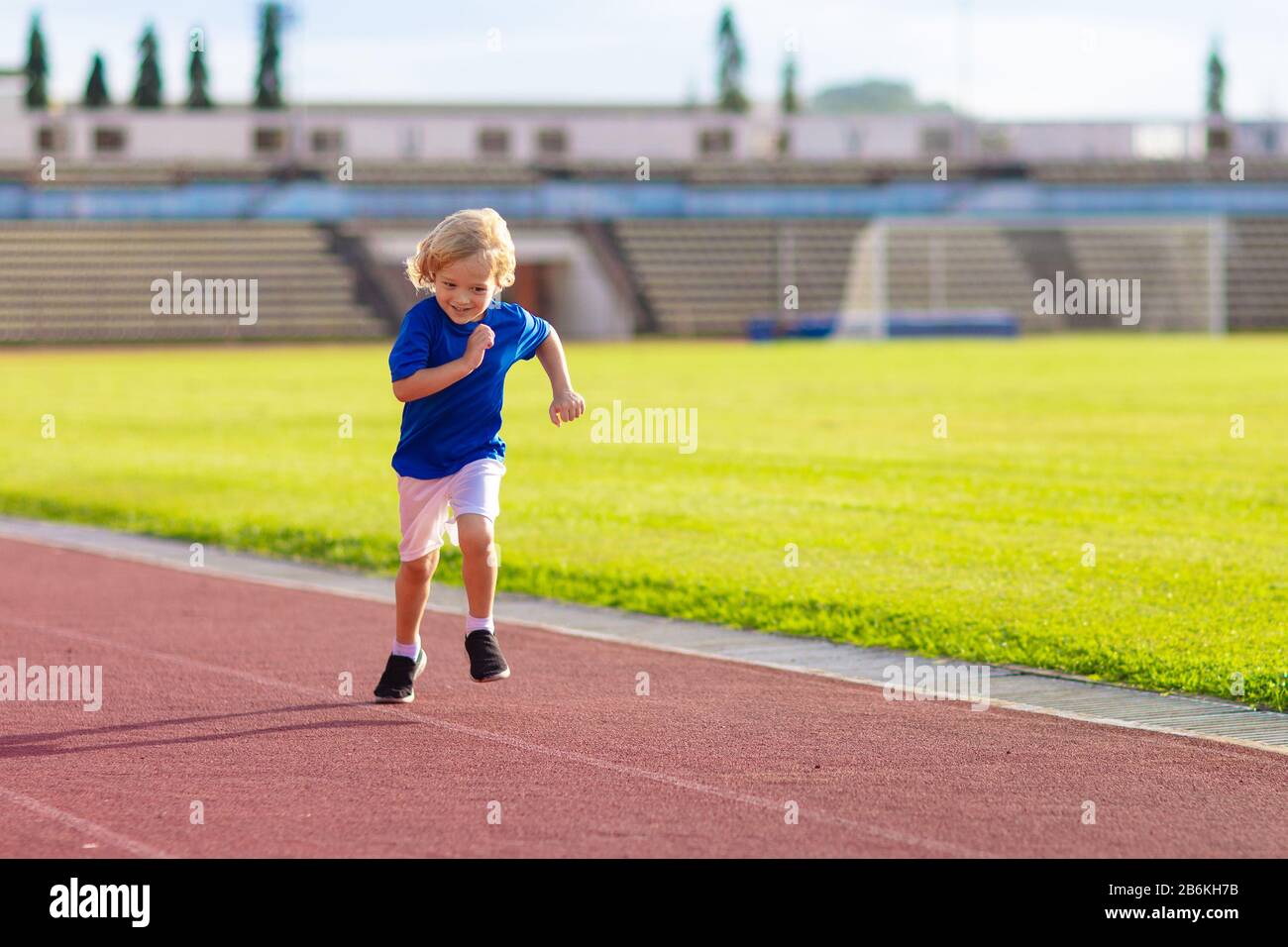 Child running in stadium. Kids run on outdoor track. Healthy sport ...