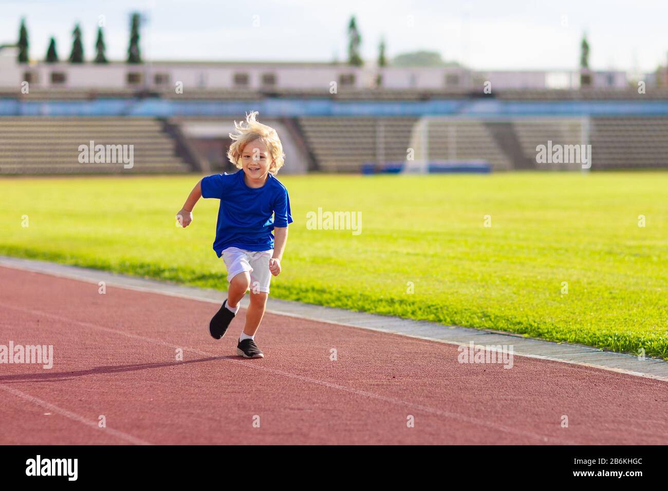 Child running in stadium. Kids run on outdoor track. Healthy sport ...