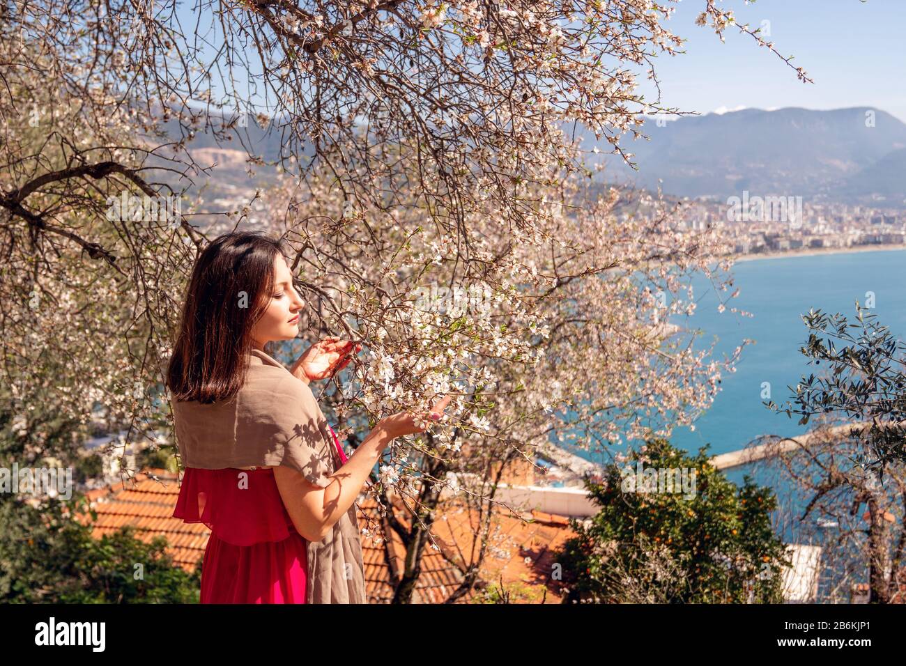 Young woman enjoying the view and the sunlight on her face under Plum ...