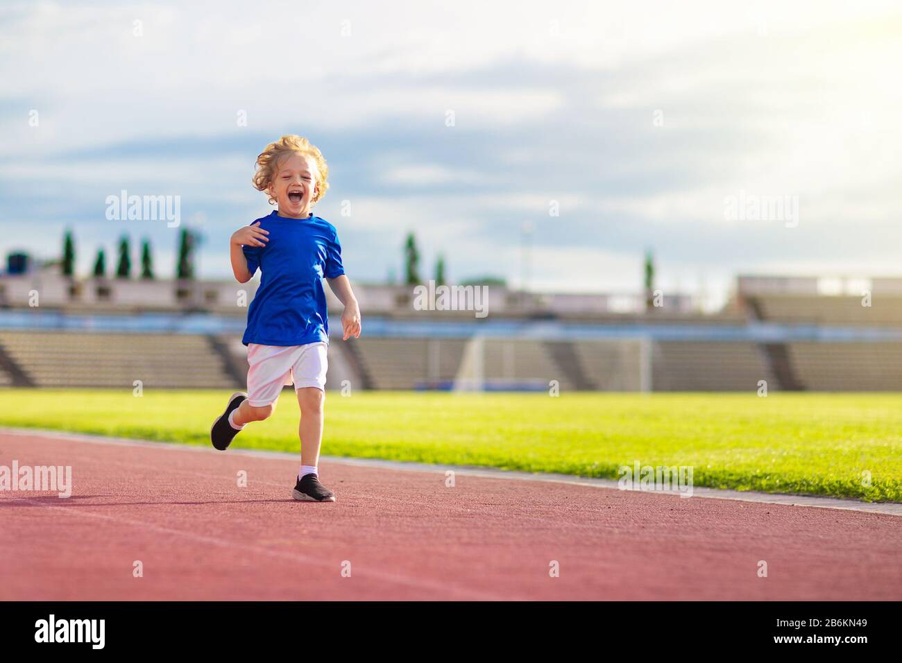 Child running in stadium. Kids run on outdoor track. Healthy sport ...