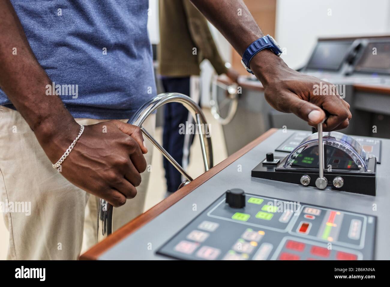 Captain's hands at the helm of a boat Stock Photo - Alamy