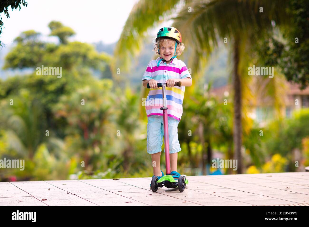 Little boy riding scooter. Kids ride kick board. Child playing on ...