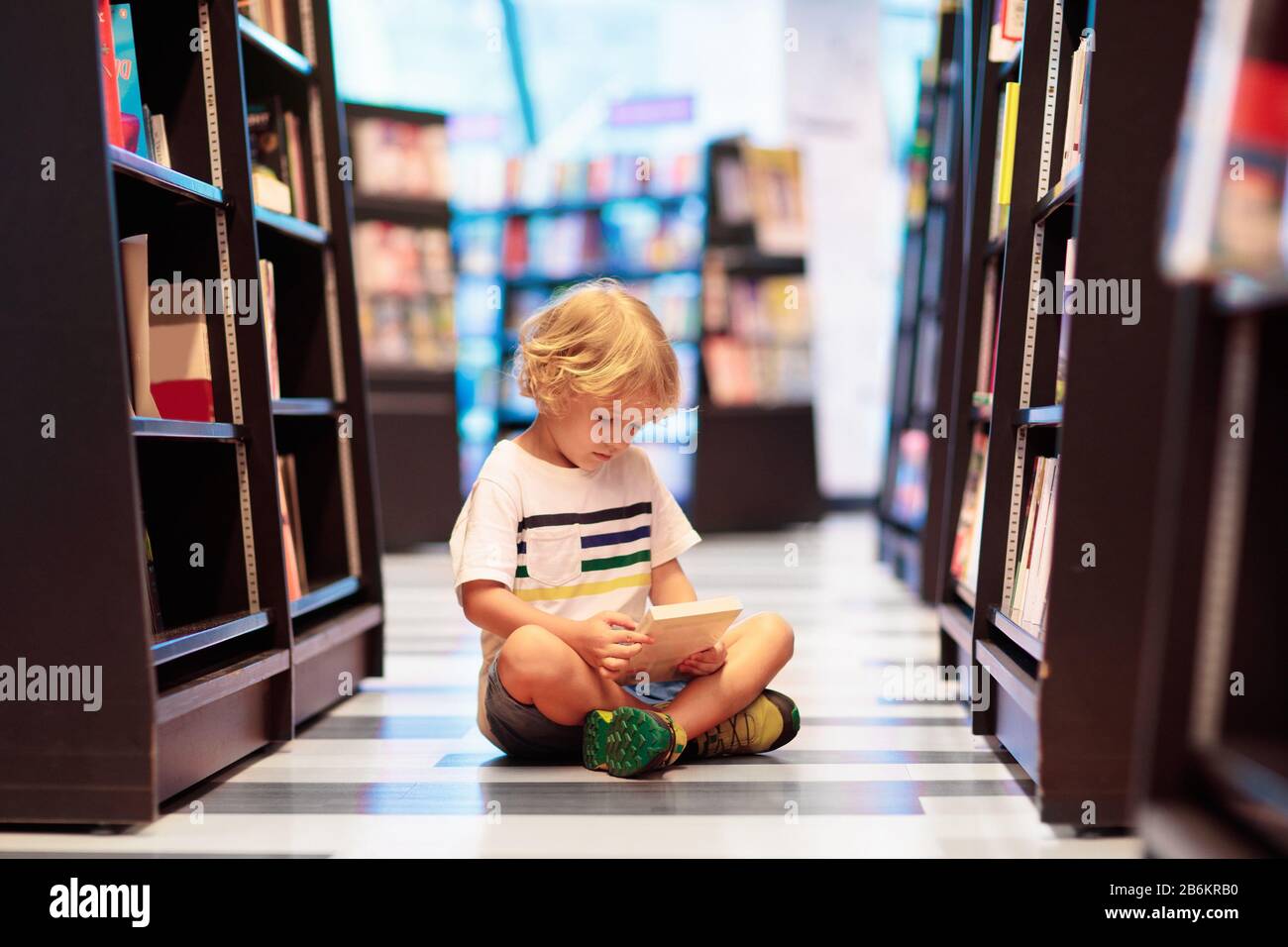 Child in school library. Kids read books. Little boy reading and ...