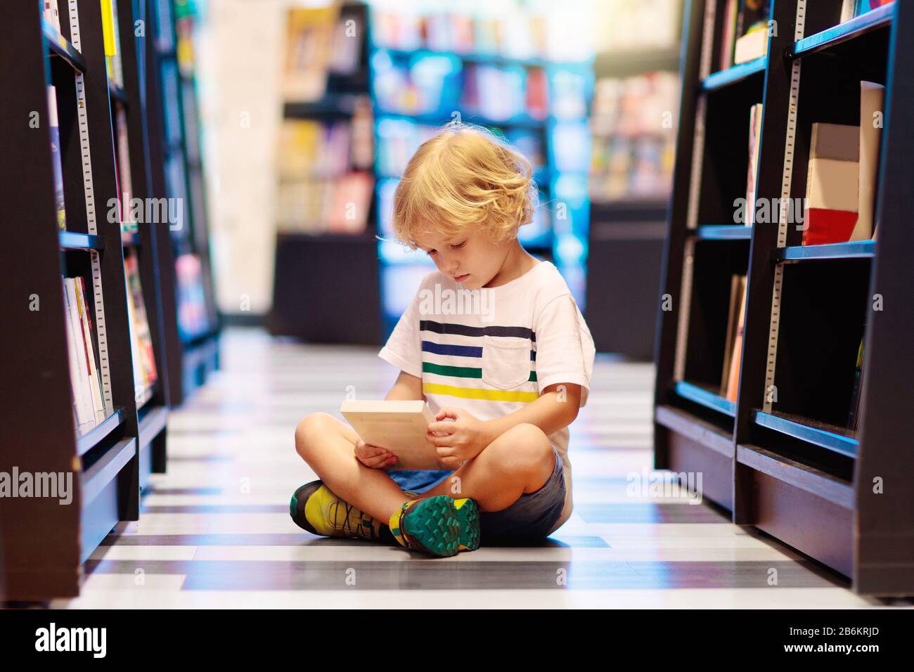 Child in school library. Kids read books. Little boy reading and ...