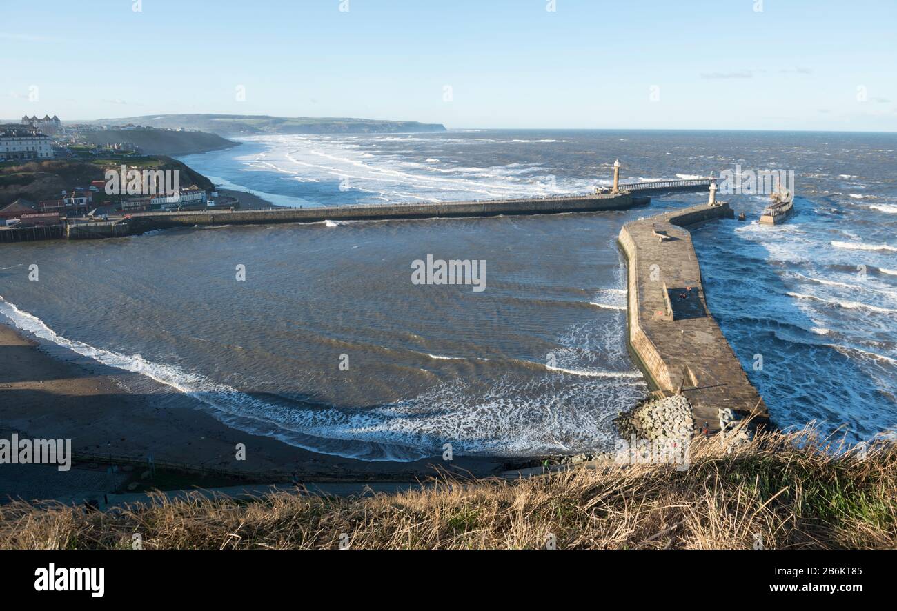 View of Whitby piers in Winter with a rough sea taken from the East ...