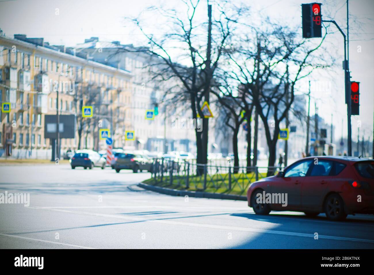 A city intersection where a red car stopped at a turn near a traffic ...