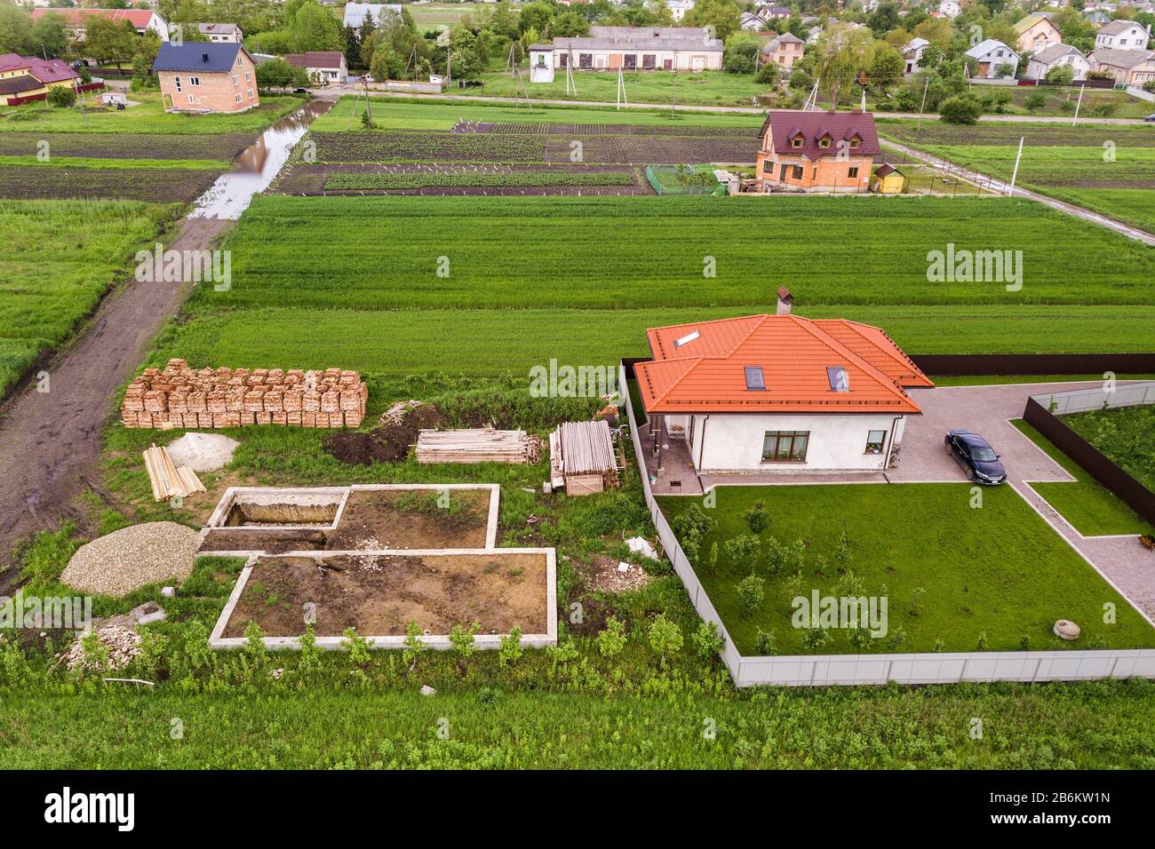 Aerial top view of a private house with attic windows on roof, paved ...
