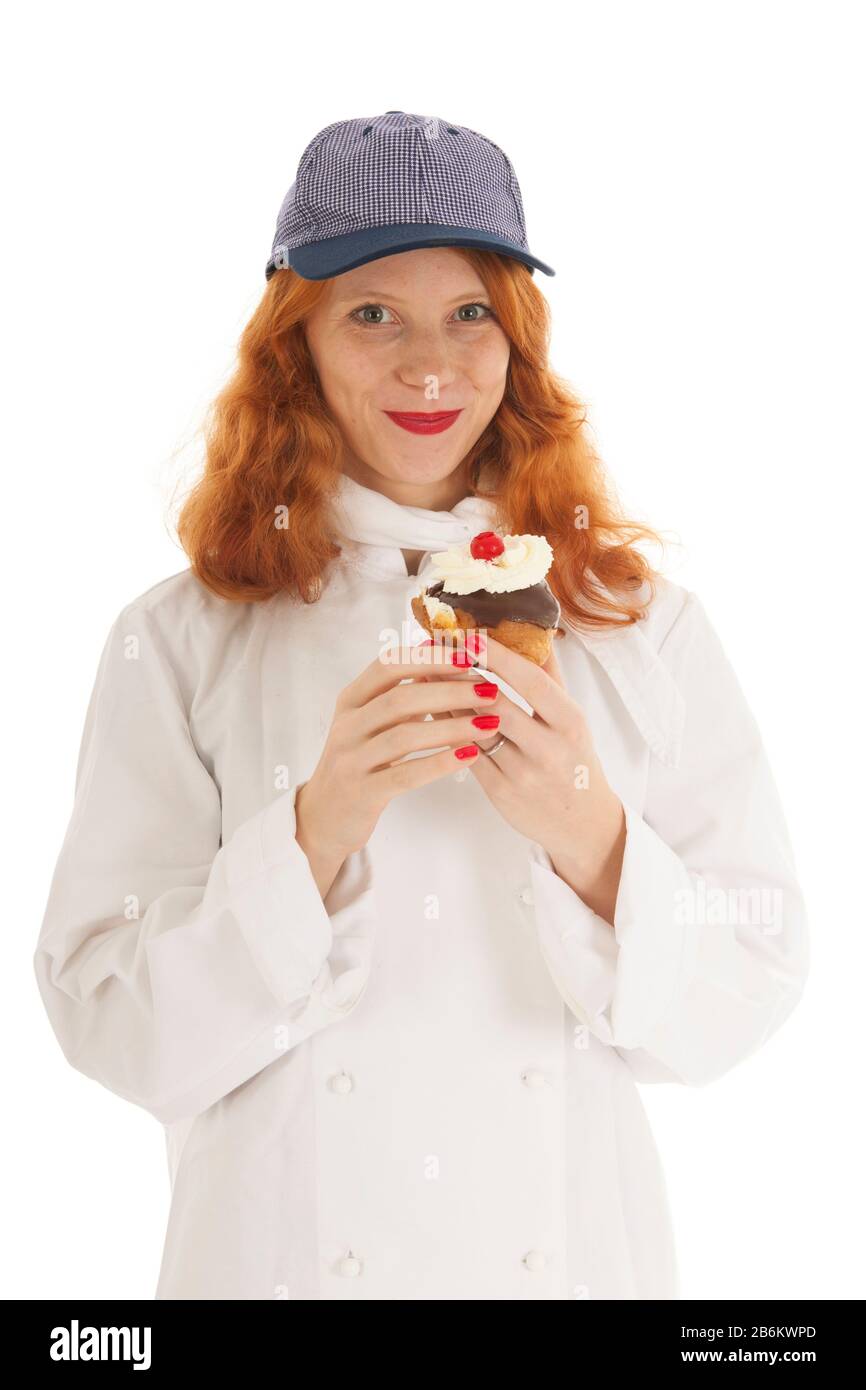 Female baker chef with red hair eating pastry isolated over white ...