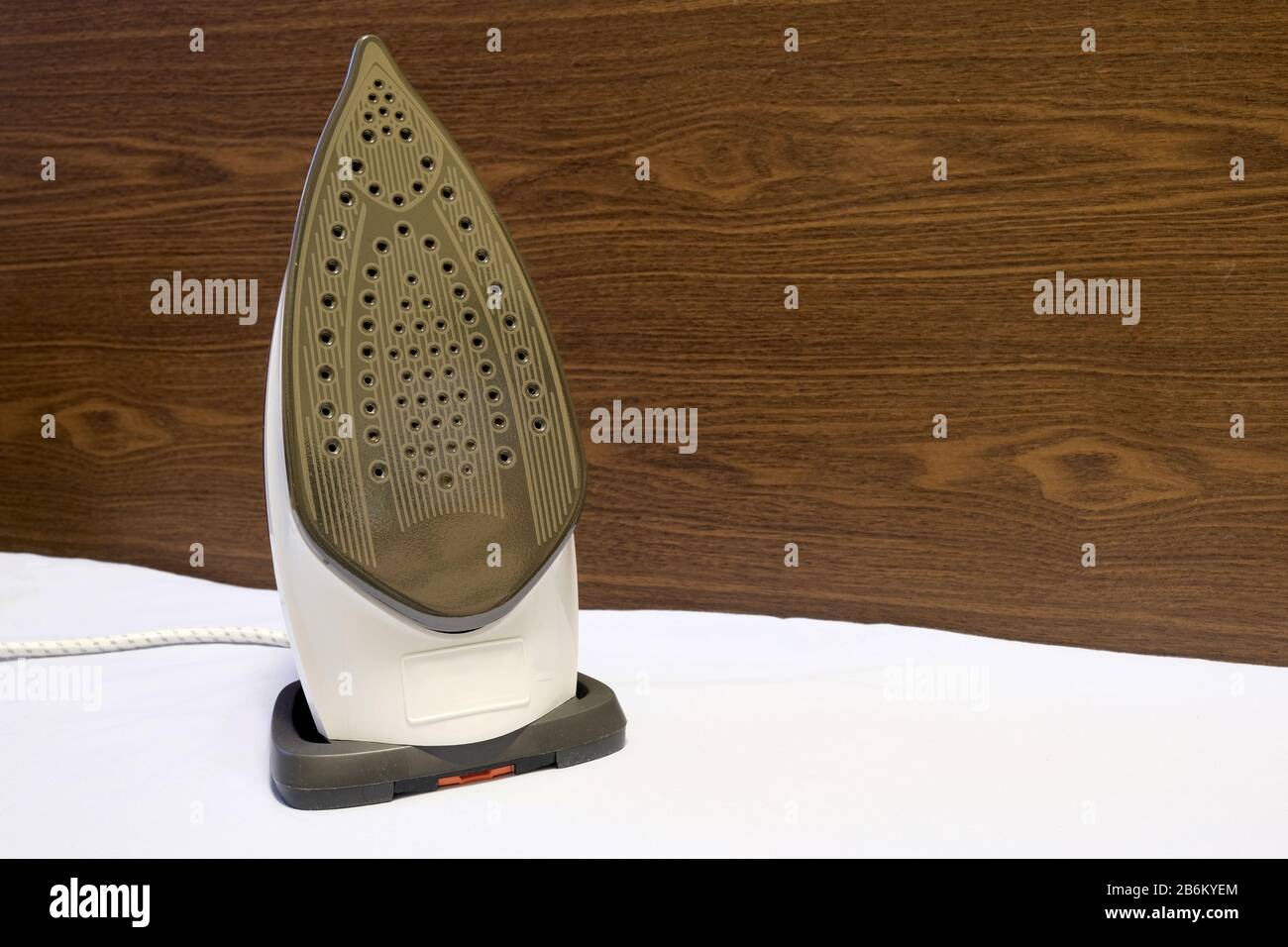 Electric iron with many steam holes on work surface stays vertical on ...