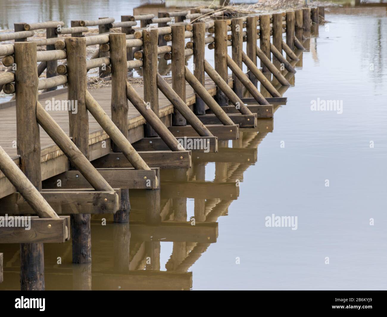 landscape with overflowing river in spring, wooden pedestrian ...