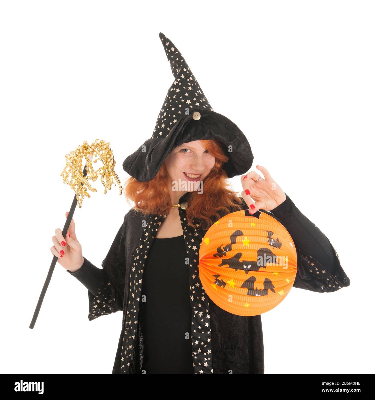 Young woman with red hair as evil witch during halloween isolated over ...