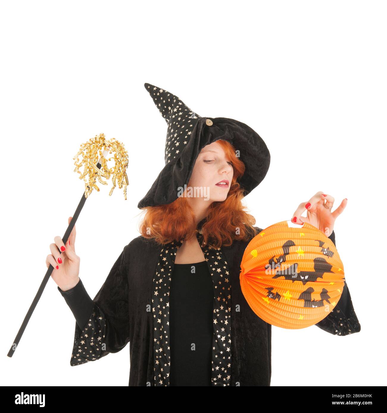 Young woman with red hair as evil witch during halloween isolated over ...