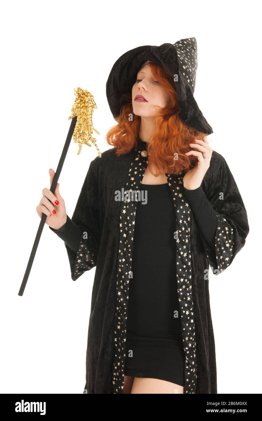 Young woman with red hair as evil witch googling with stick isolated ...