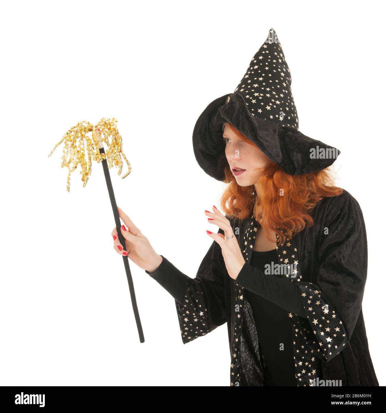 Young woman with red hair as evil witch isolated over white background ...