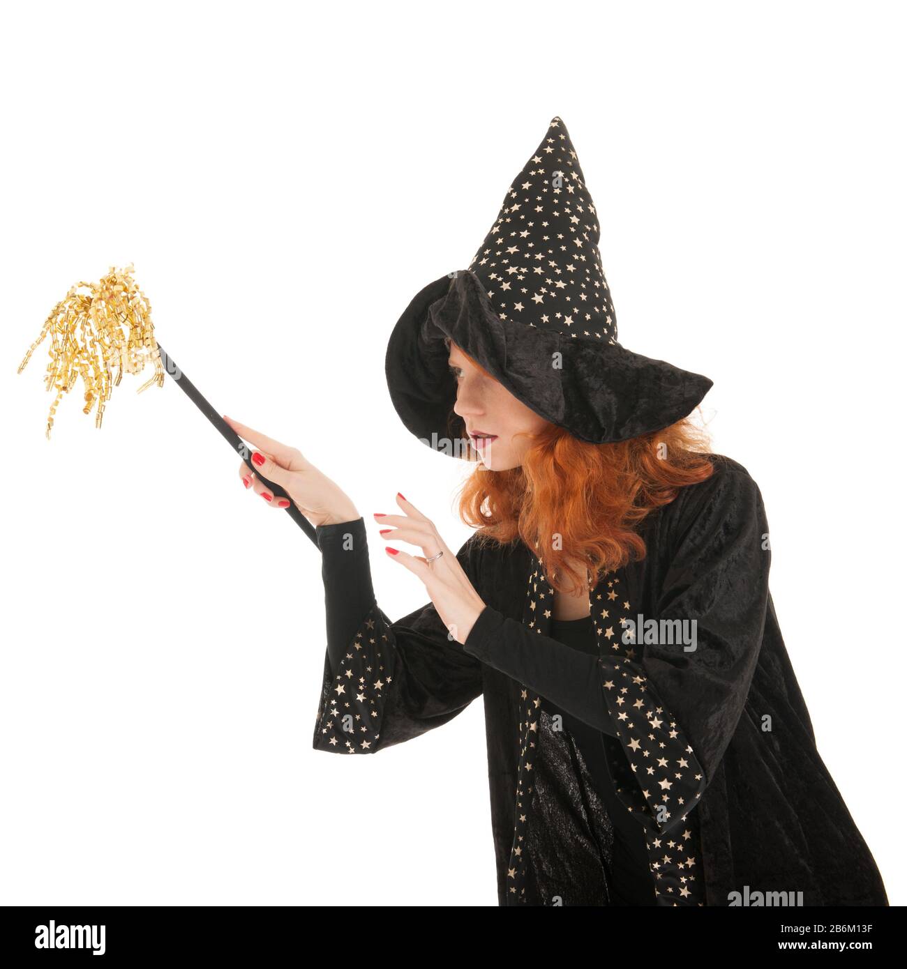 Young woman with red hair as evil witch isolated over white background ...