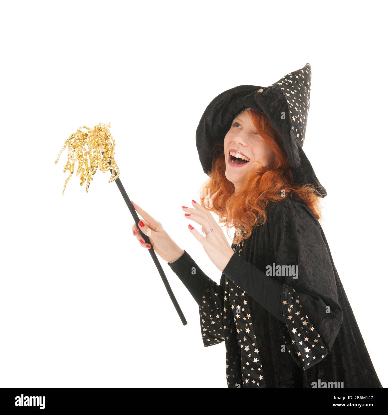 Young woman with red hair happy as evil witch isolated over white ...