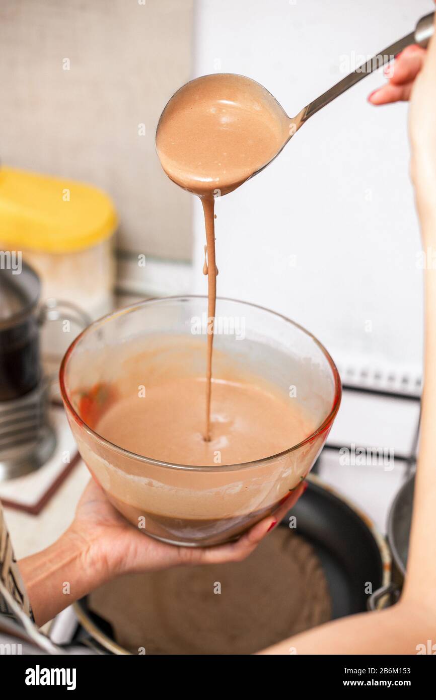 Laying process of liquid chocolate biscuit dough in a baking dish at ...