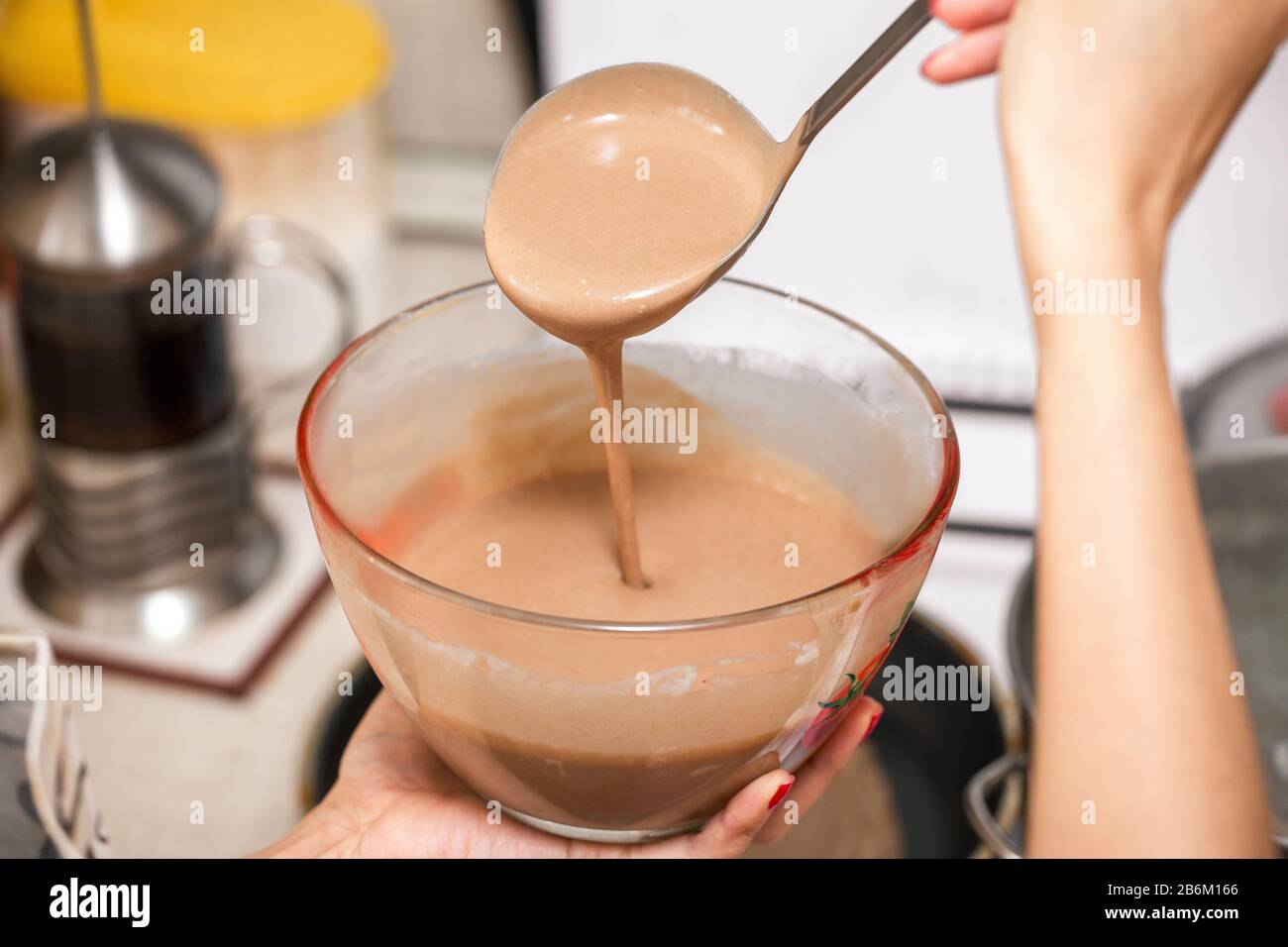 Laying process of liquid chocolate biscuit dough in a baking dish at ...