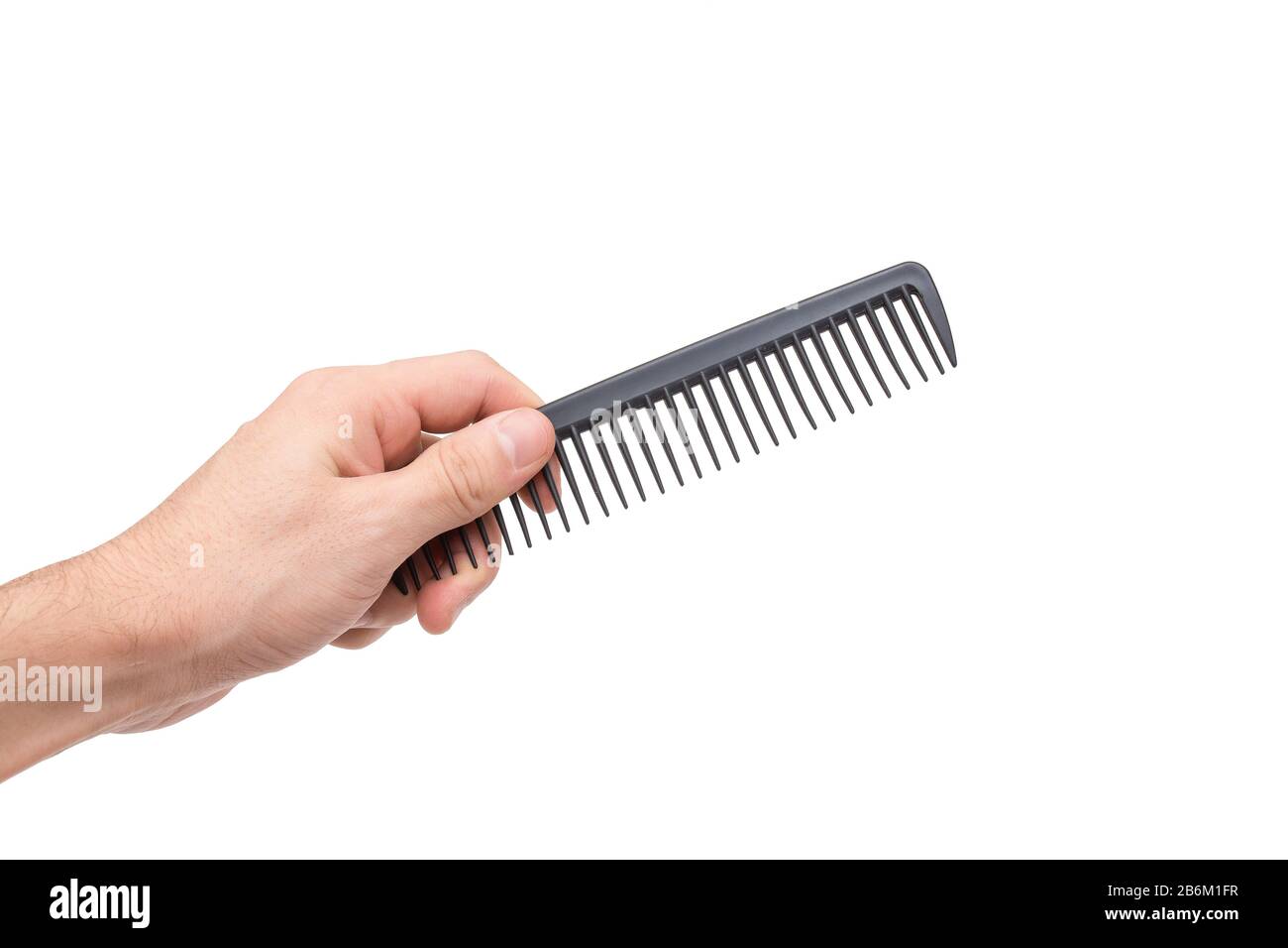 Black comb in hand isolated on white Stock Photo - Alamy
