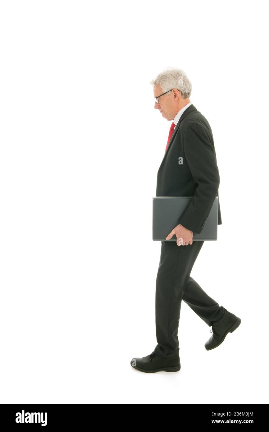 Formally dressed Senior business man walking with laptop Stock Photo ...