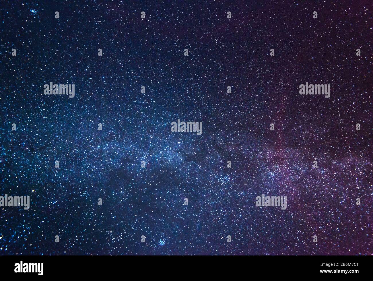 Stunning starry sky on a cloudless winter night amid a blue-pink fog ...