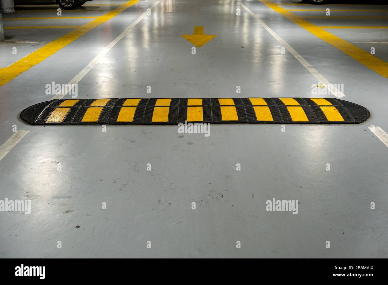 Striped black and yellow speed bump on a road Stock Photo - Alamy