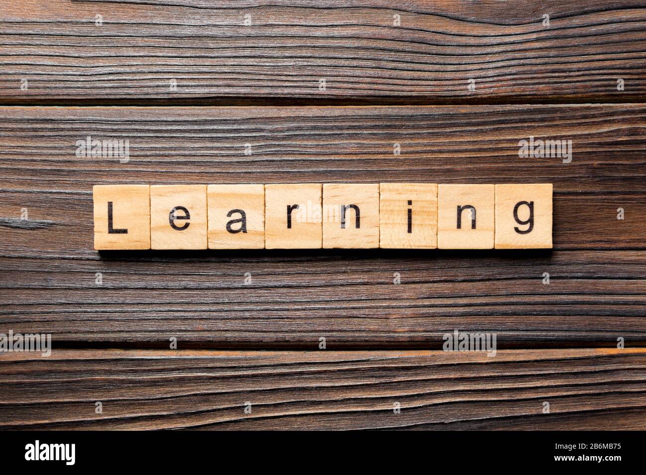 LEARNING word written on wood block. LEARNING text on wooden table for ...