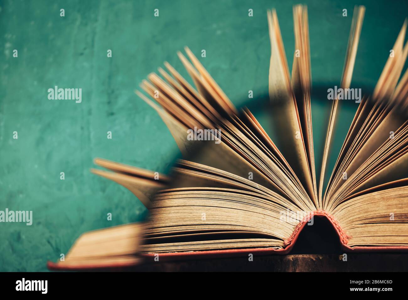 Beautiful abstract open book on a old wooden table and Green wall ...