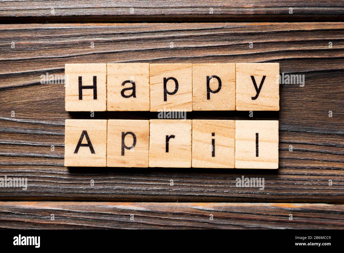 Happy april word written on wood block. Happy april text on table ...