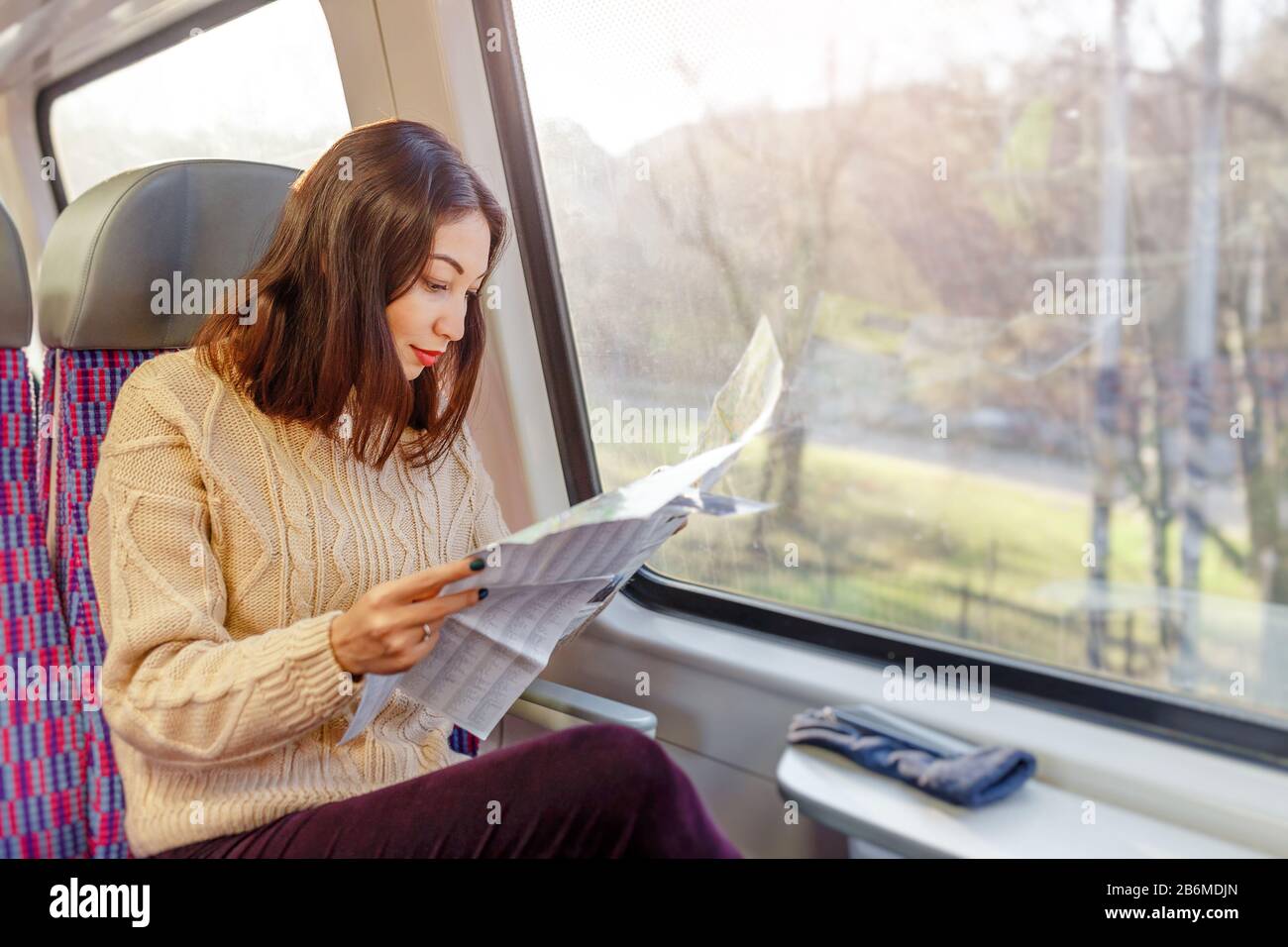 Woman traveler inside the train reading the map or newspaper Stock ...