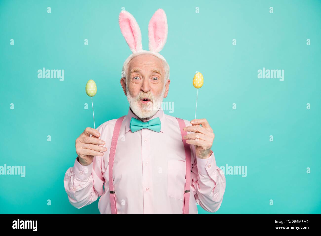 Portrait of astonished grandfather man celebrate easter party hold ...