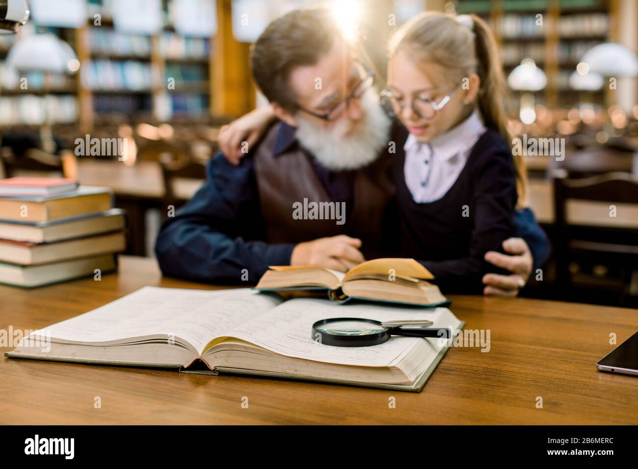 Grandfather and granddaughter reading a book in old vintage city ...