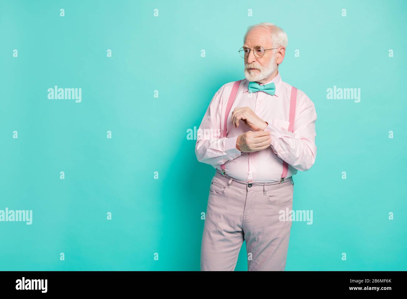 Photo of attractive serious hipster grandpa preparing senior meeting party buttoning sleeve look ...