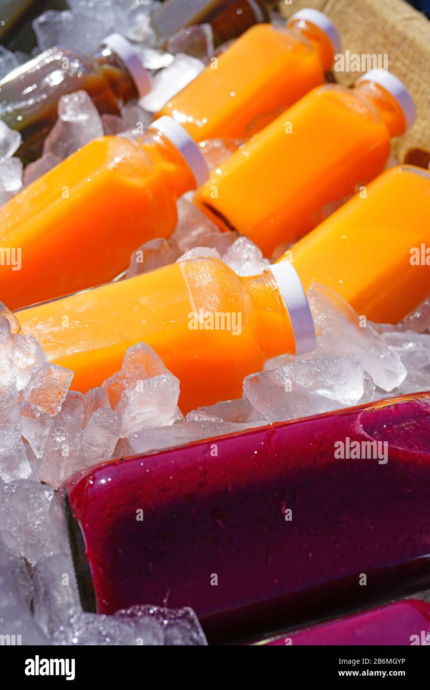 Bottles of colorful cold pressed juice on ice Stock Photo - Alamy