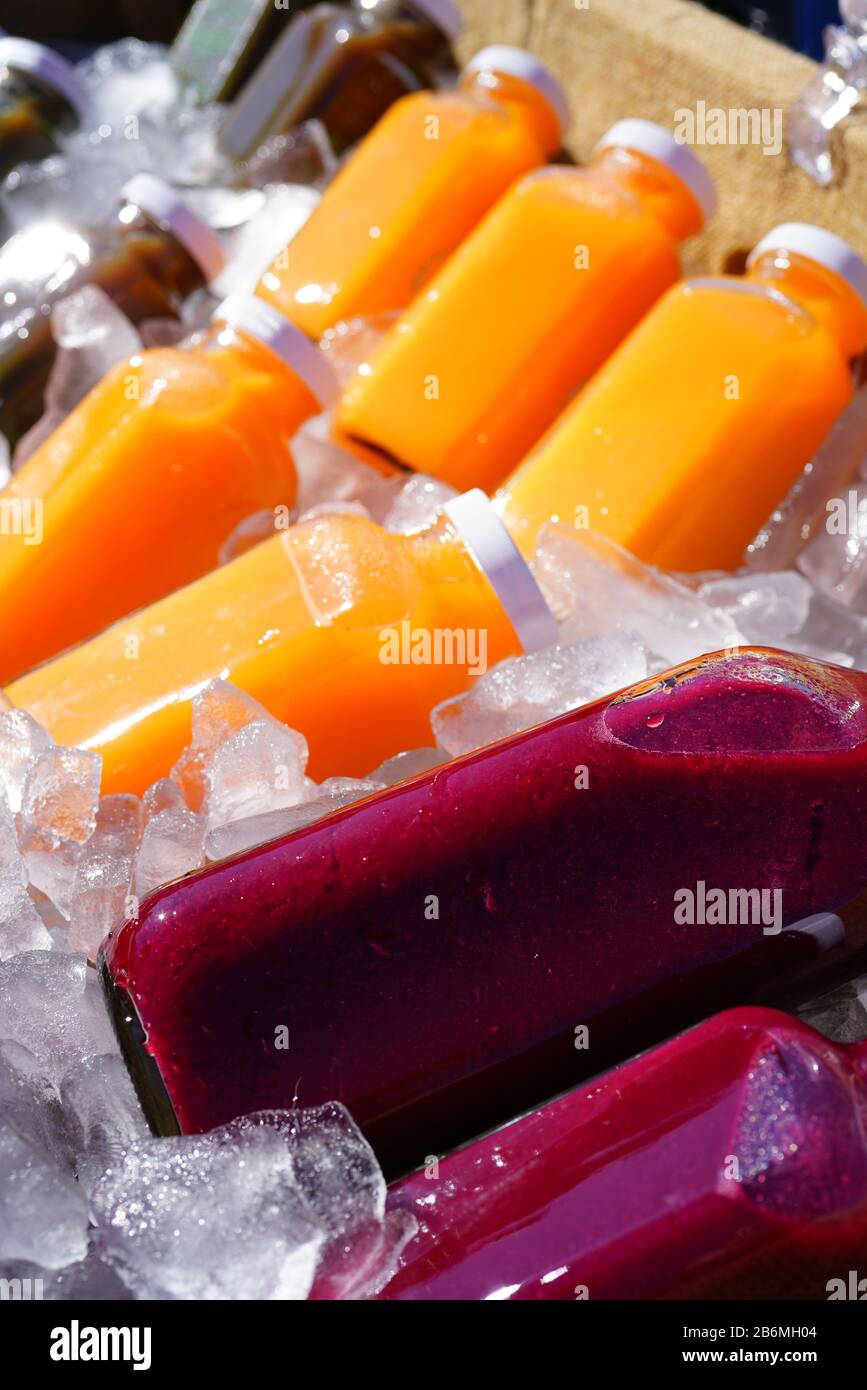 Bottles of colorful cold pressed juice on ice Stock Photo - Alamy