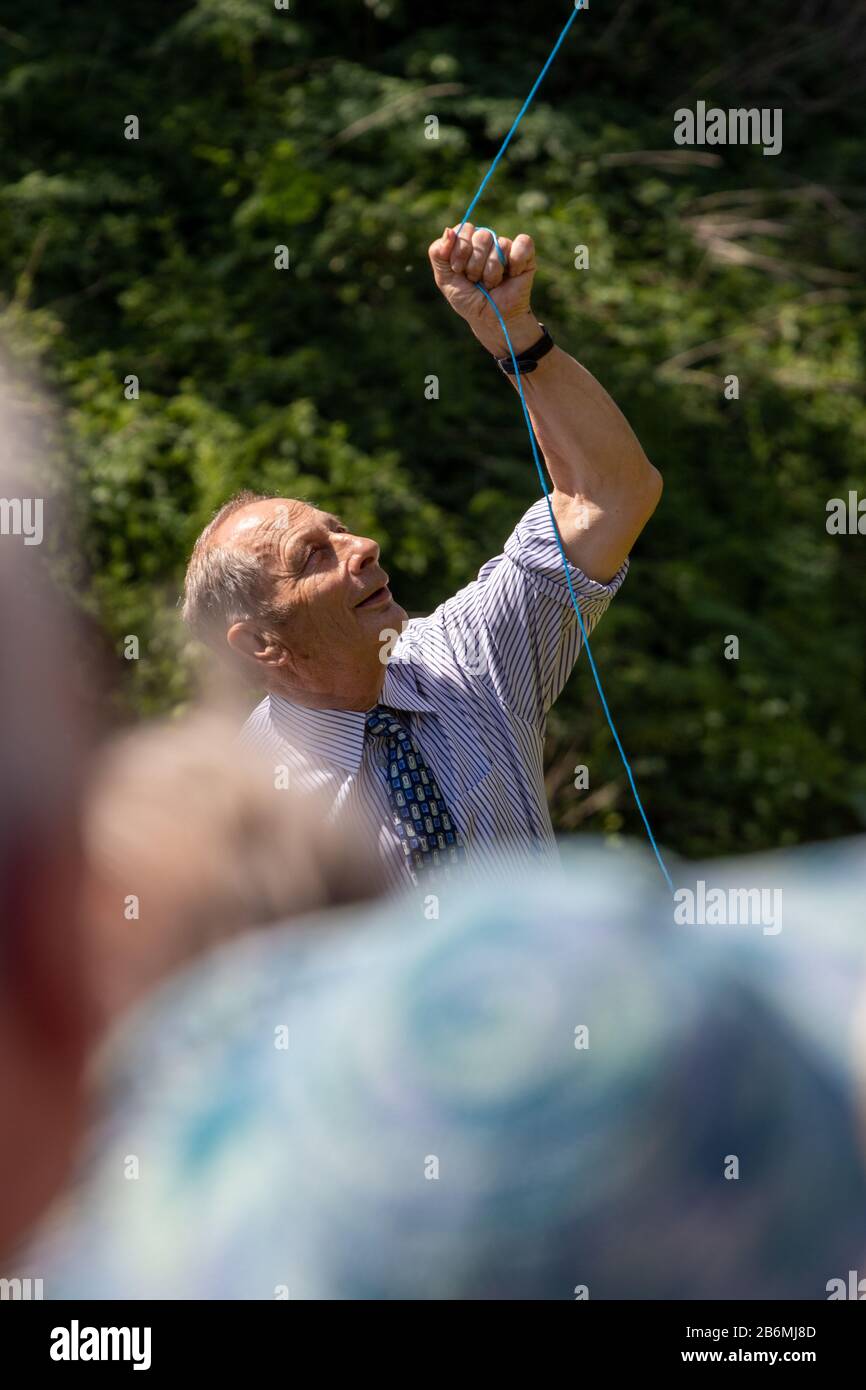 Man about to pull string to reveal new village sign Stock Photo - Alamy