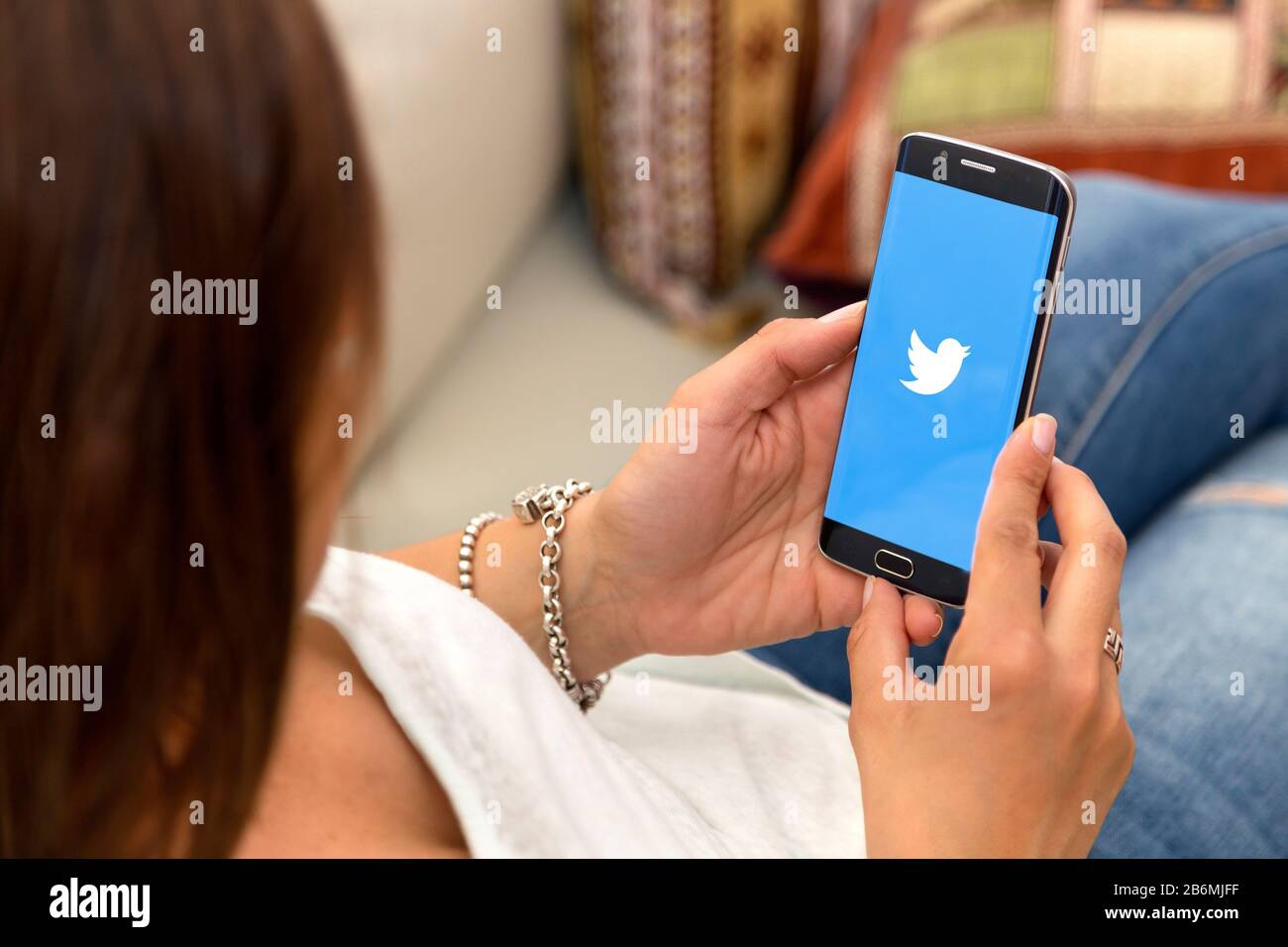 Twitter. Girl with smartphone in her hands and a Twitter logo on the ...