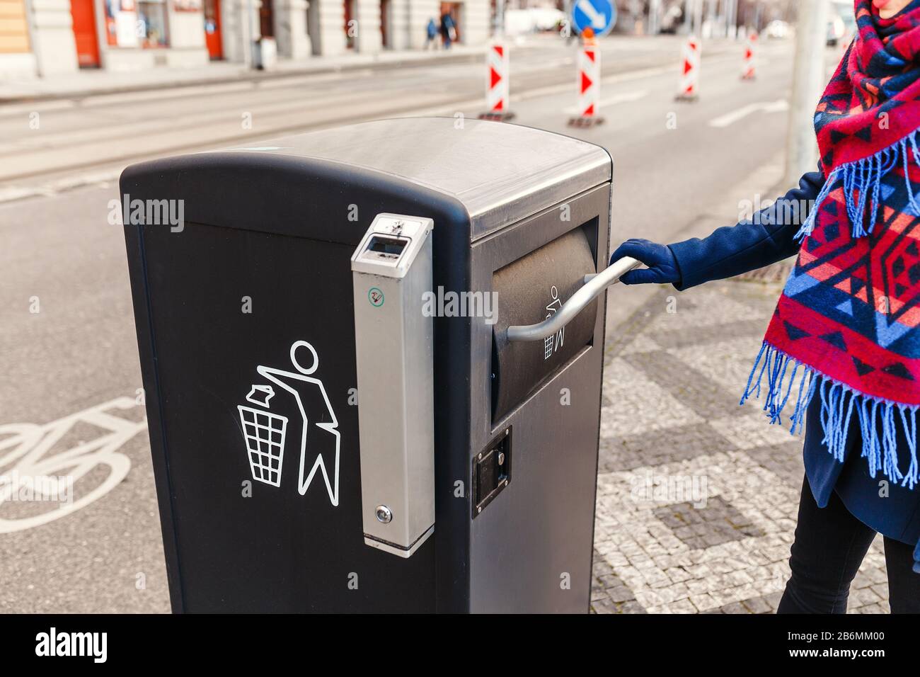 Woman throwing garbage in street recycling container Stock Photo - Alamy