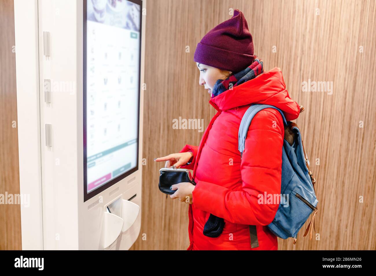 A woman orders meal in the touch screen terminal in the electronic menu ...