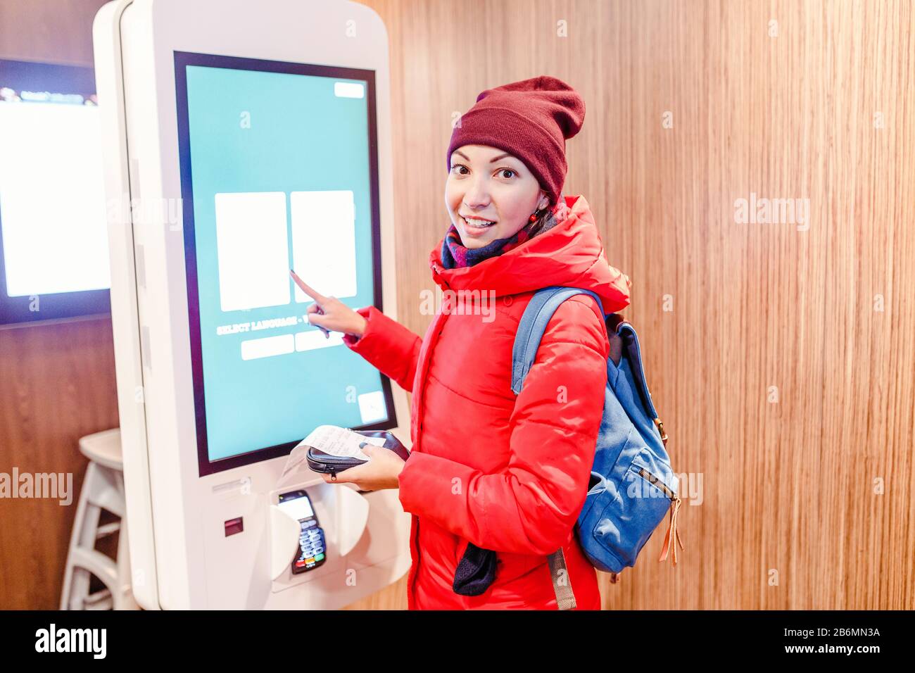 A woman orders meal in the touch screen terminal in the electronic menu ...