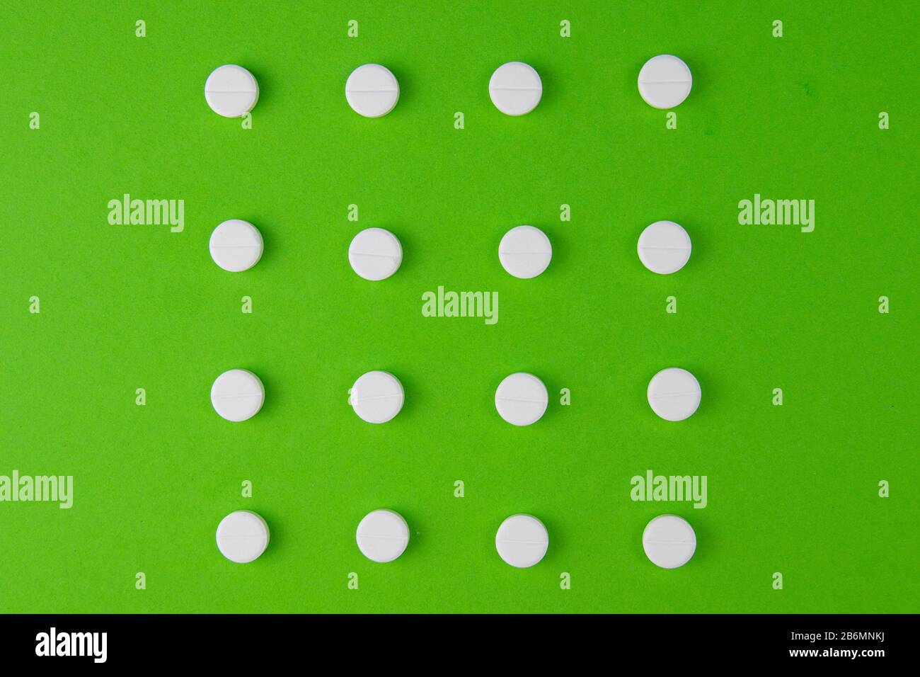 white pills laid out in the shape of a square on a green background ...