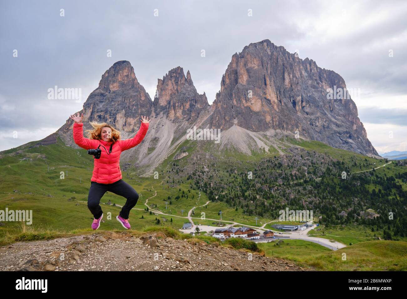 Happy photographer jumping with her arms up in the air, wearing a ...