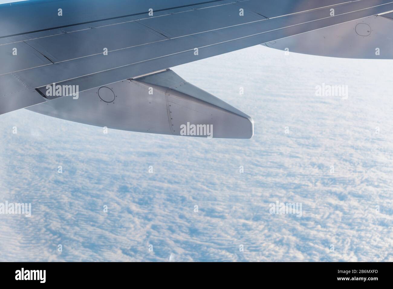 Aircraft wing view from airplane with cloudy sky at sunset Stock Photo ...
