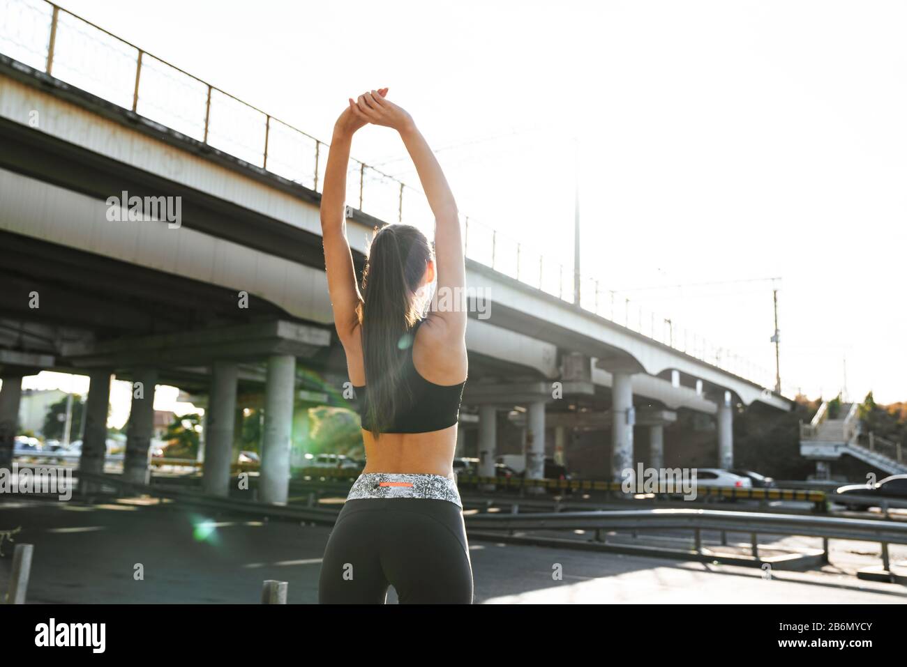 Back view photo of a young sports fitness woman make stretching ...