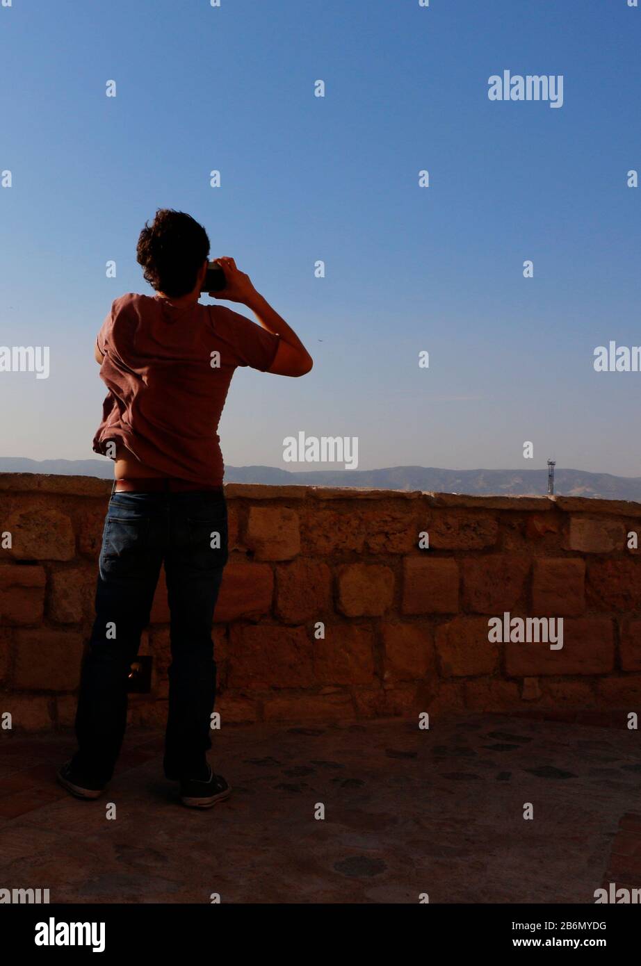 Male model standing in front of an ancient wall in Marseille while ...