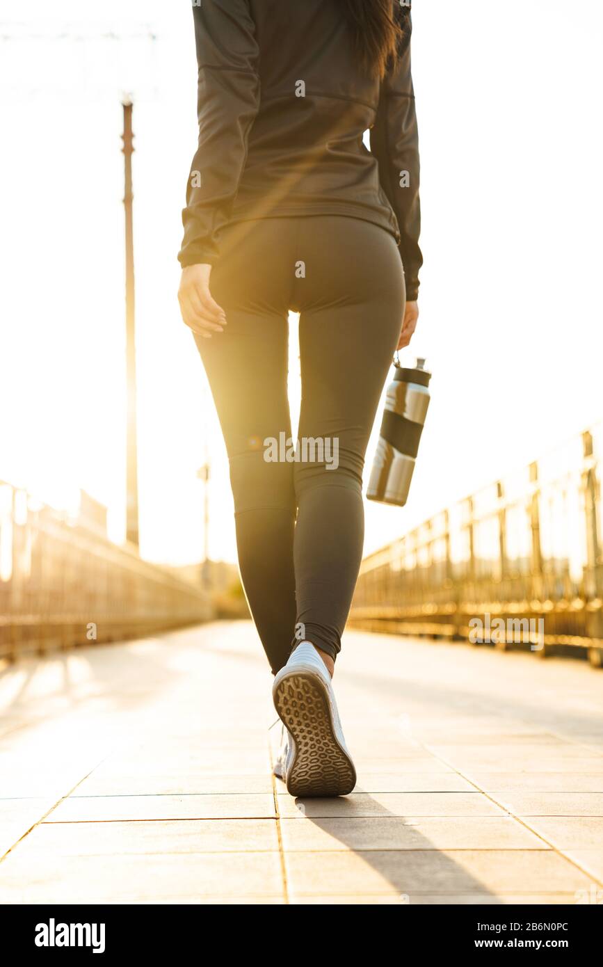 Cropped photo of a strong young sports fitness woman walking outdoors ...