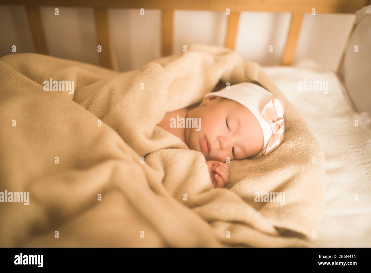 Cute newborn baby with a bandage on his head sleeps sweetly in the ...