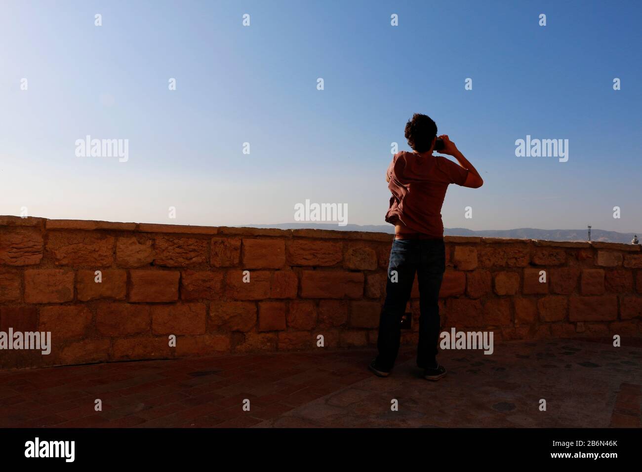 Male model standing in front of an ancient wall in Marseille while ...